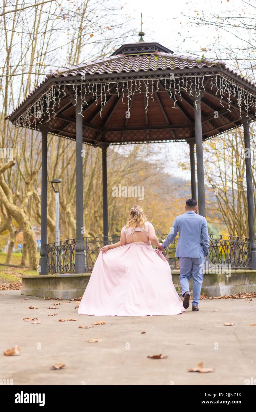 A vertical shot of the newly married couple walking in the post-wedding ...