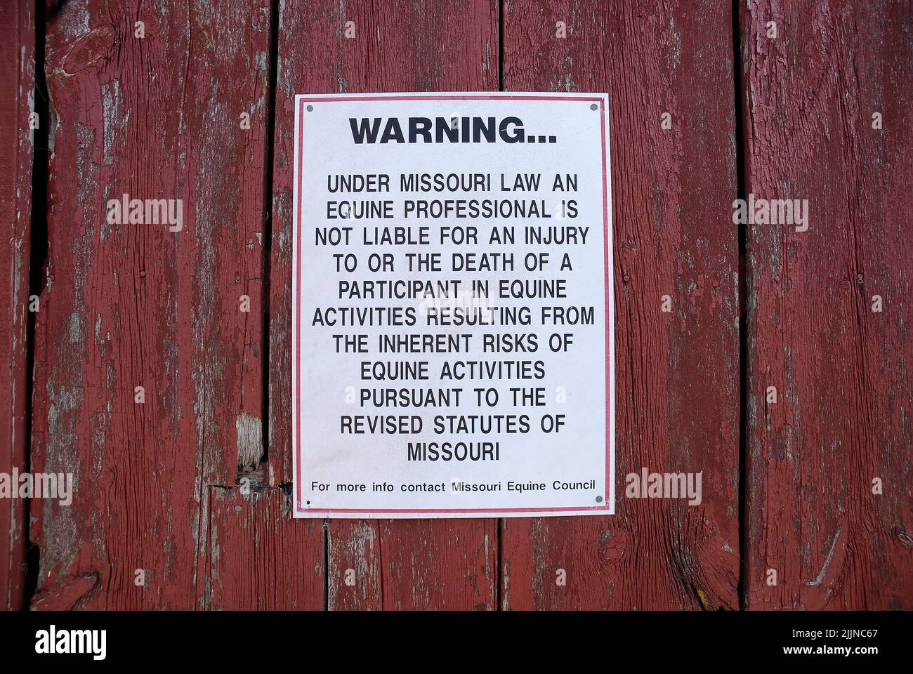 A posted warning sign referencing legal liabilities at an equine ...