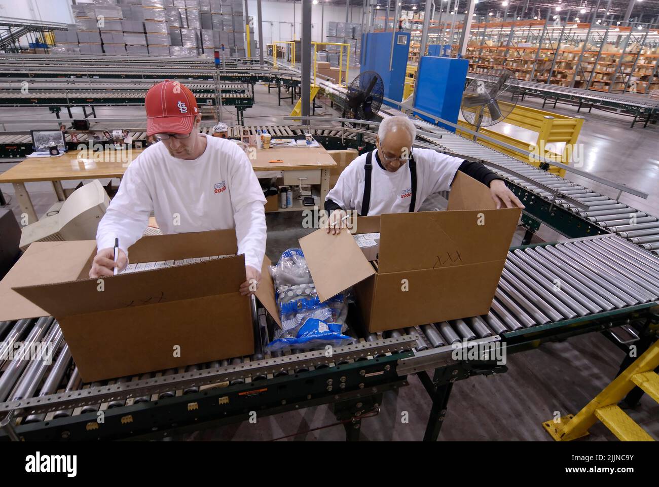 The Workers loading products in boxes on a conveyor belt in a shipping ...