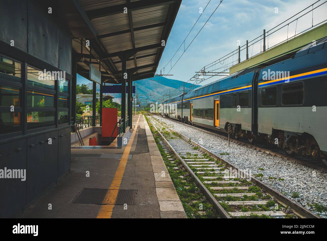 Double decker train passing by the train station in Italy Stock Photo ...