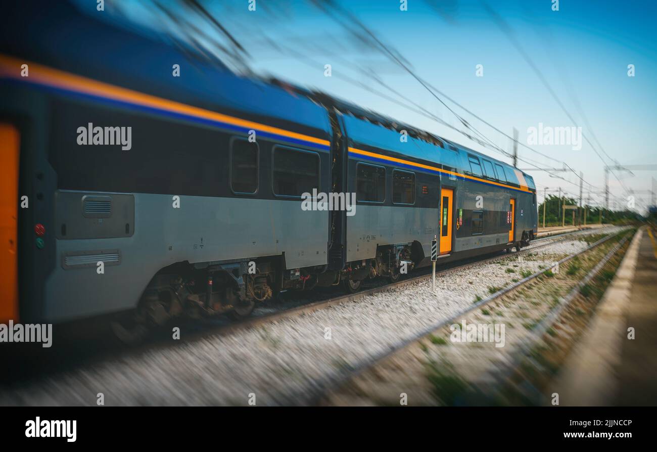 Double decker train passing by the train station in Italy Stock Photo ...