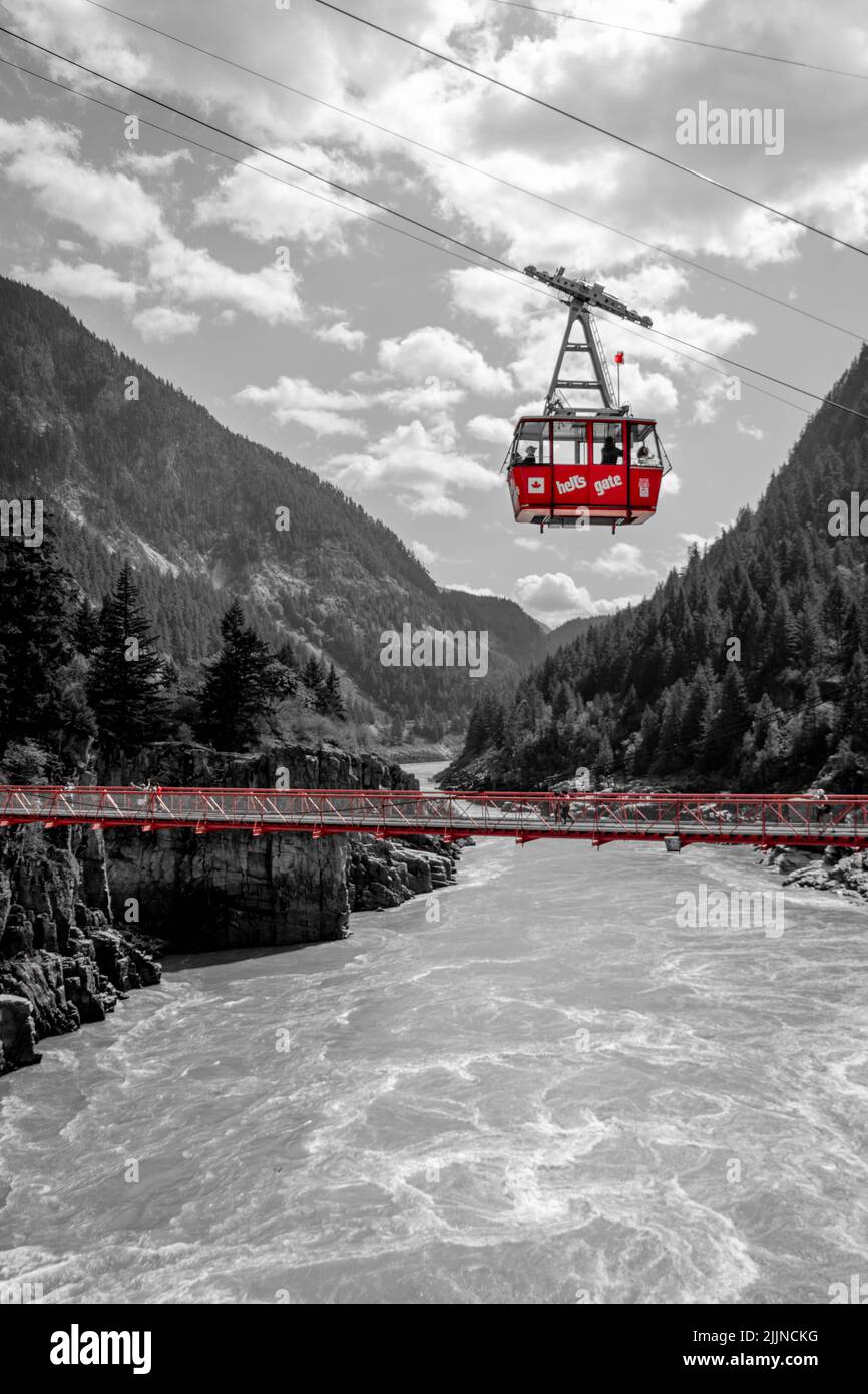 A vertical shot of a cable car over a river in the rocky mountains in ...