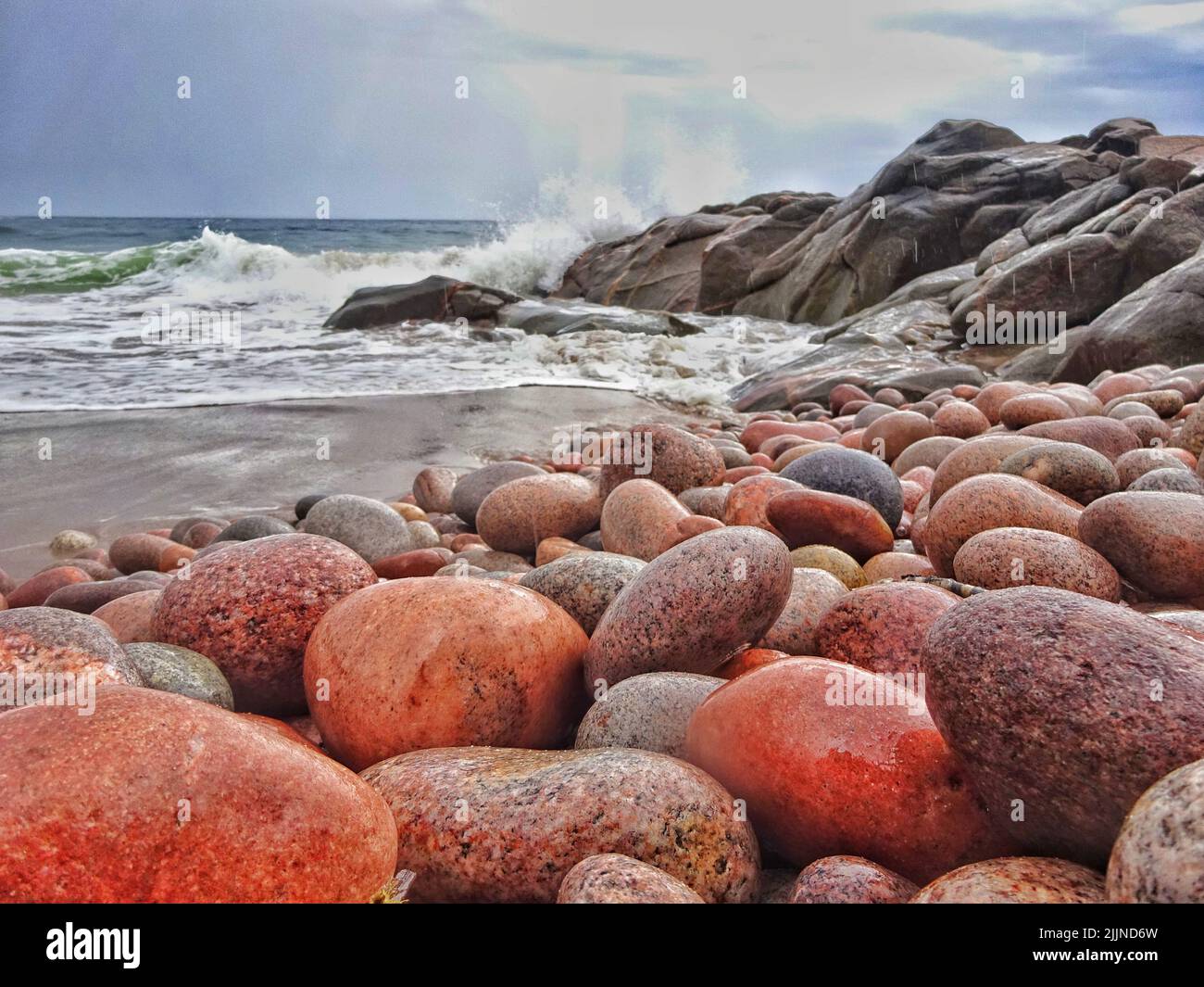 A beautiful view of an ocean with rocks on the beach Stock Photo - Alamy