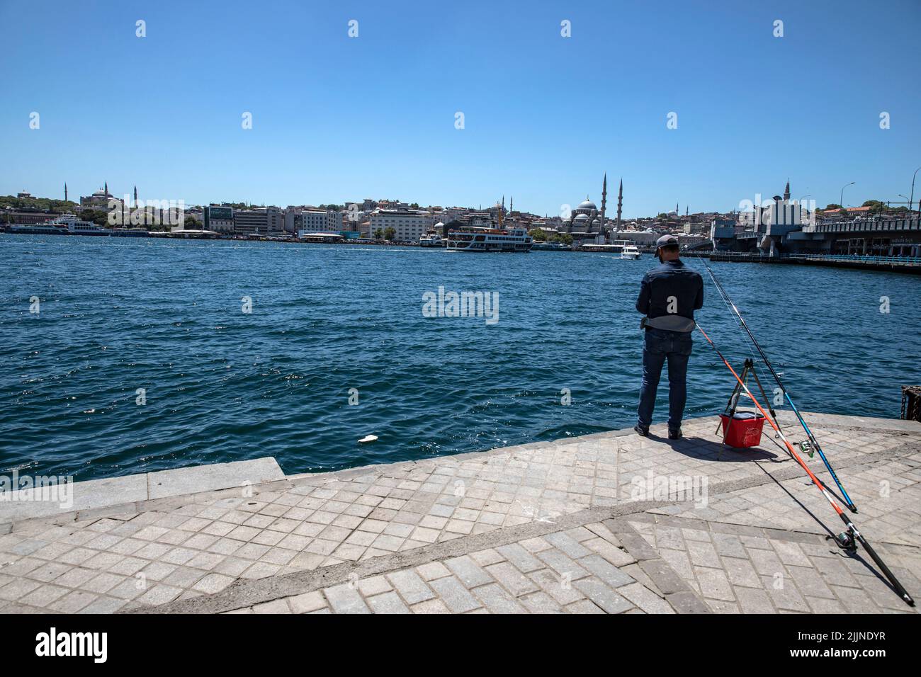 A man is seen fishing on the Karakoy beach at noon Stock Photo - Alamy
