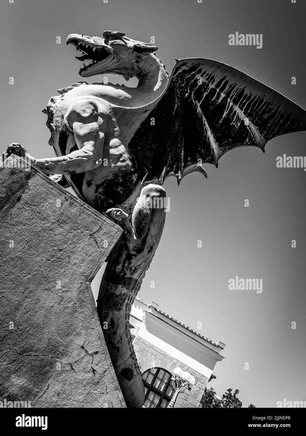 A vertical shot of an old winged dragon sculpture in grayscale Stock ...