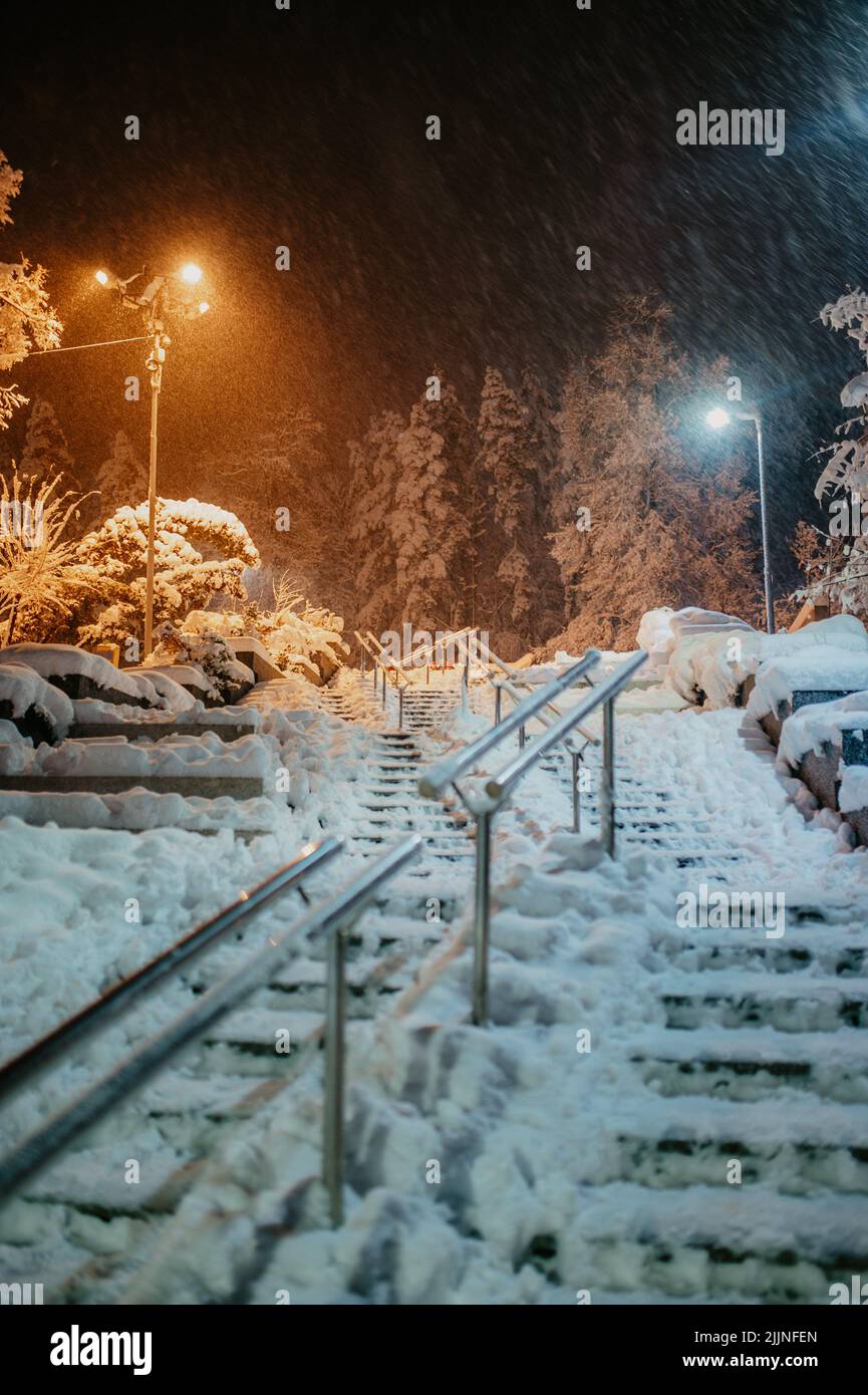 A vertical view of staircase fully covered in snow during night Stock ...