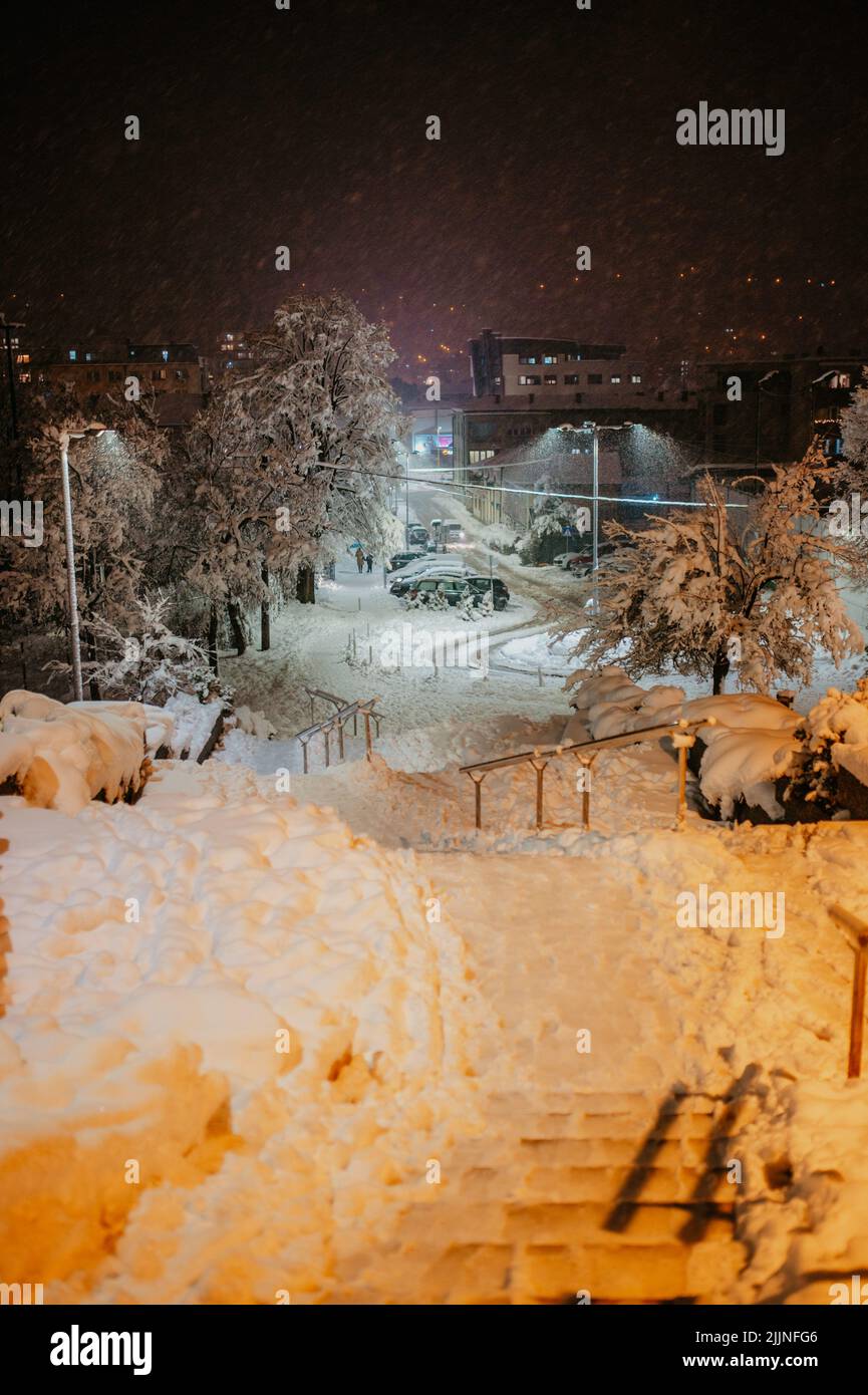 A vertical view of a staircase fully covered in snow during night Stock ...
