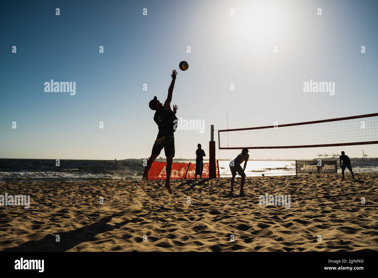 A low angle shot of a volleyball player jumping to hit the ball in the ...
