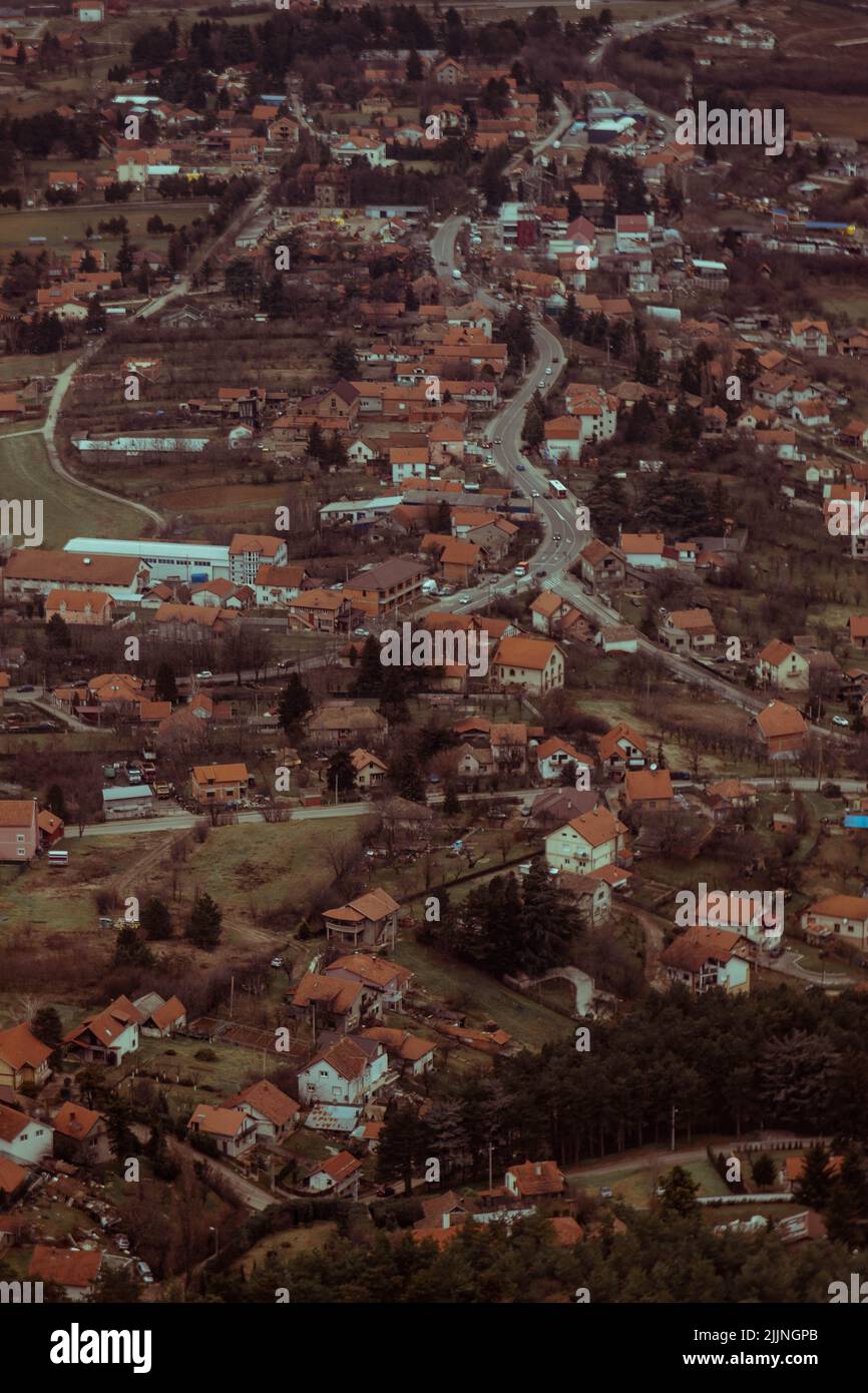 A vertical aerial view of a cityscape with small rural buildings and ...