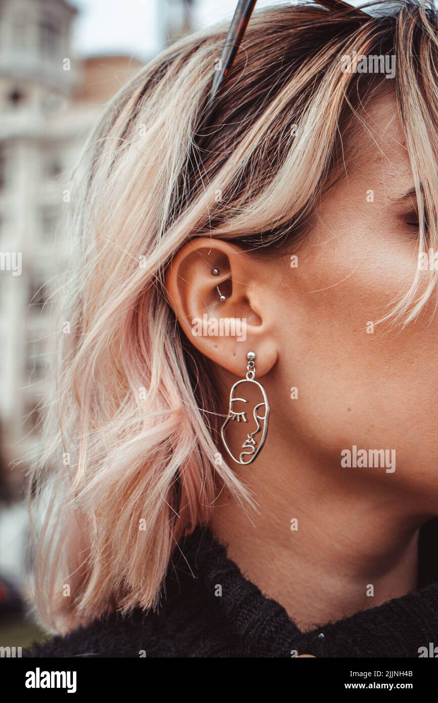 A vertical side view of a female wearing handmade earrings Stock Photo ...