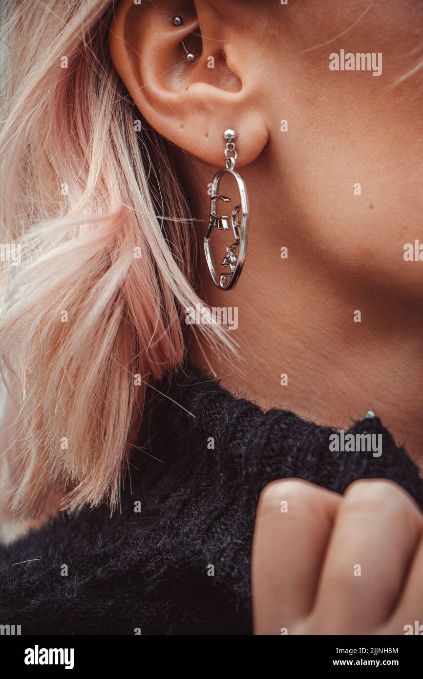 A vertical side view of a female wearing handmade earrings Stock Photo ...