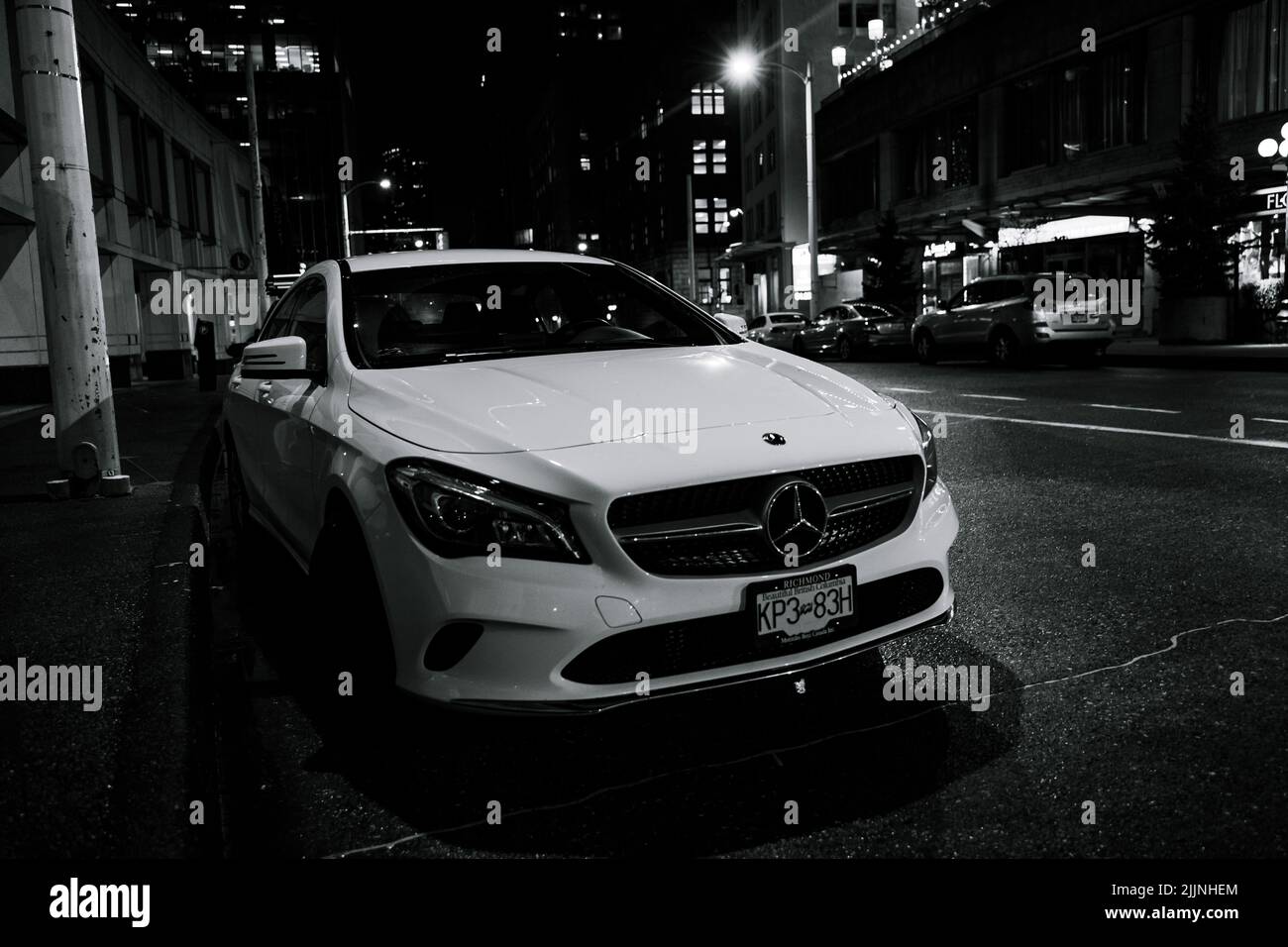 A grayscale of Mercedes sports car parked on the side of the road in ...