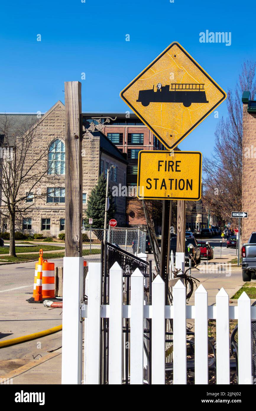 Fire station sign on city street with church building and construction ...