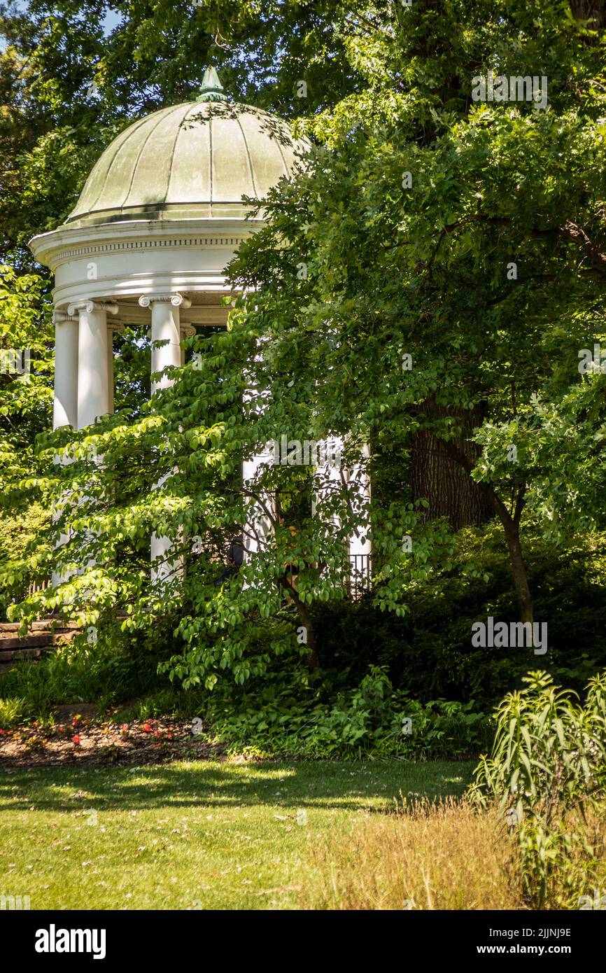 Garden pavilion with columns in lushly wooded area in summertime partly ...