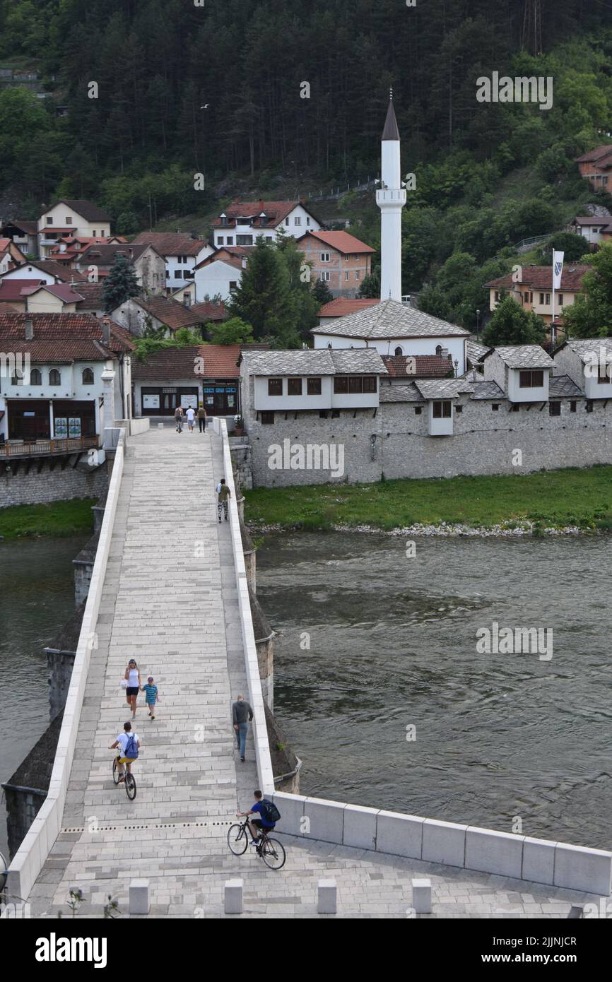 A vertical shot of a bridge crossing the river connecting to a town ...