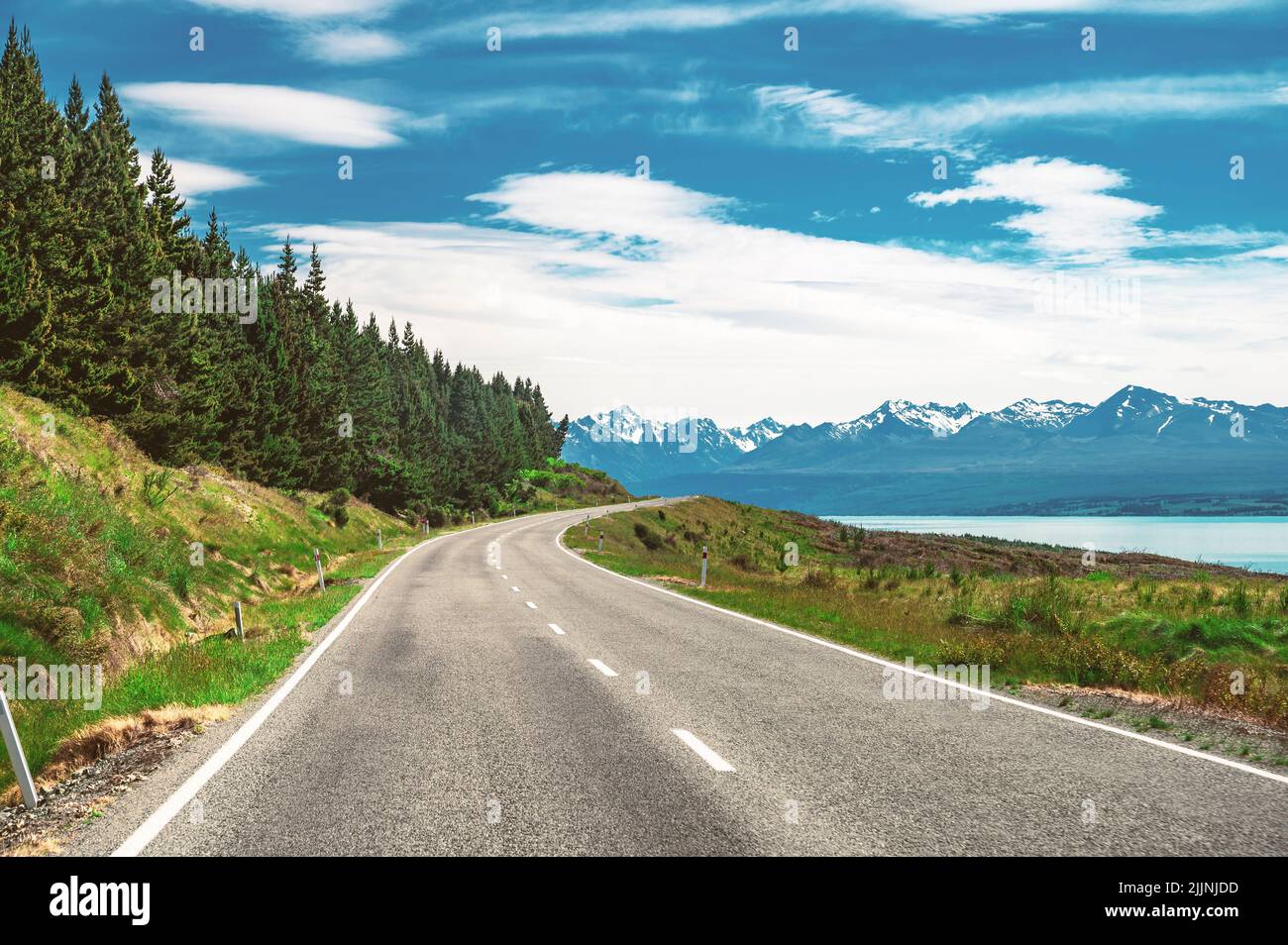 The cloudy blue sky over the highway and Mt. Cook and Pukaki Lake ...