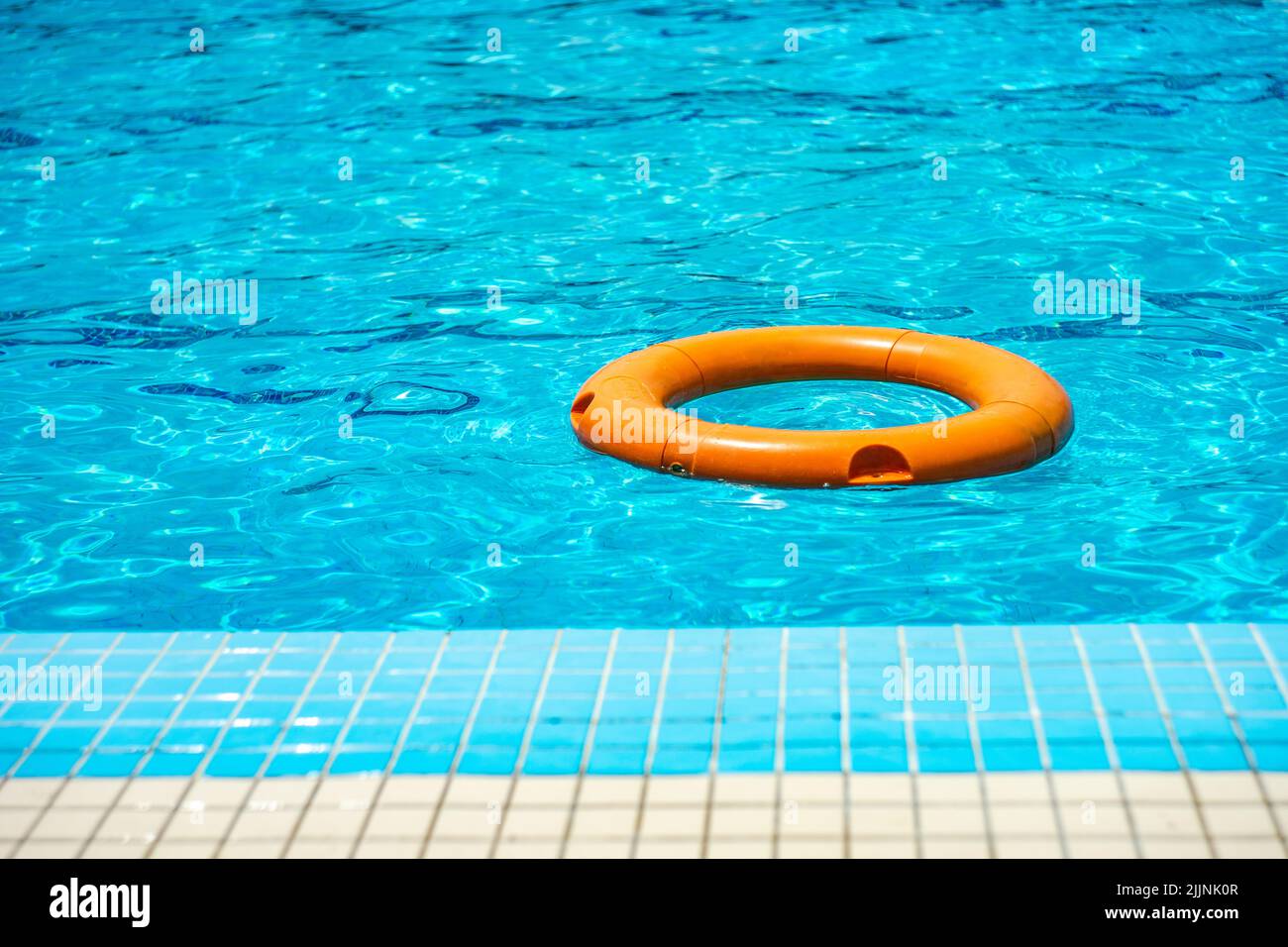 Life belt floating in a swimming pool Stock Photo - Alamy