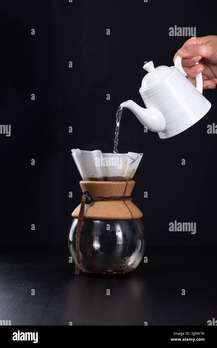 A vertical closeup of the coffee brewing on black background Stock ...