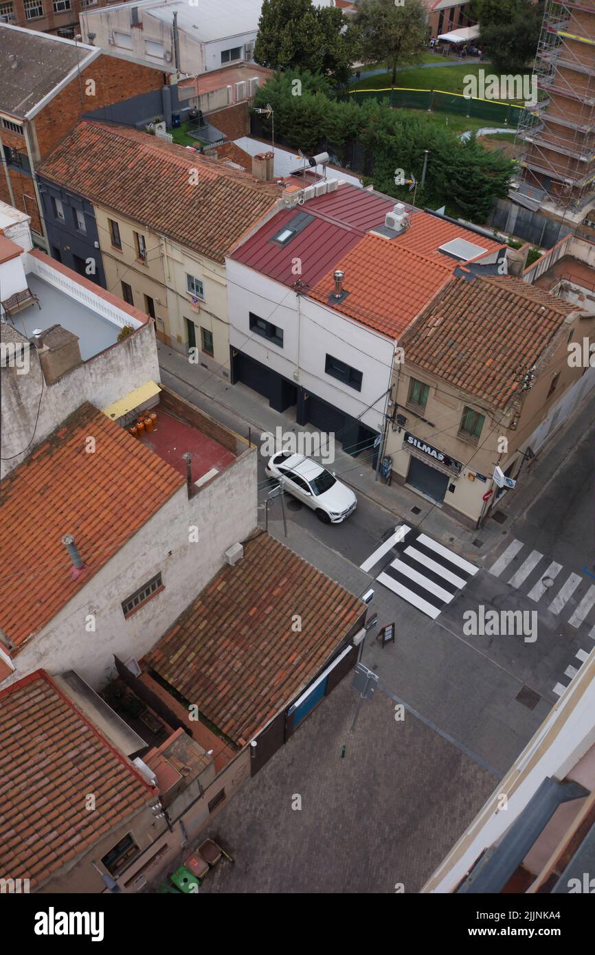 An aerial view of a white car stopped in front of a pedestrian crossing ...