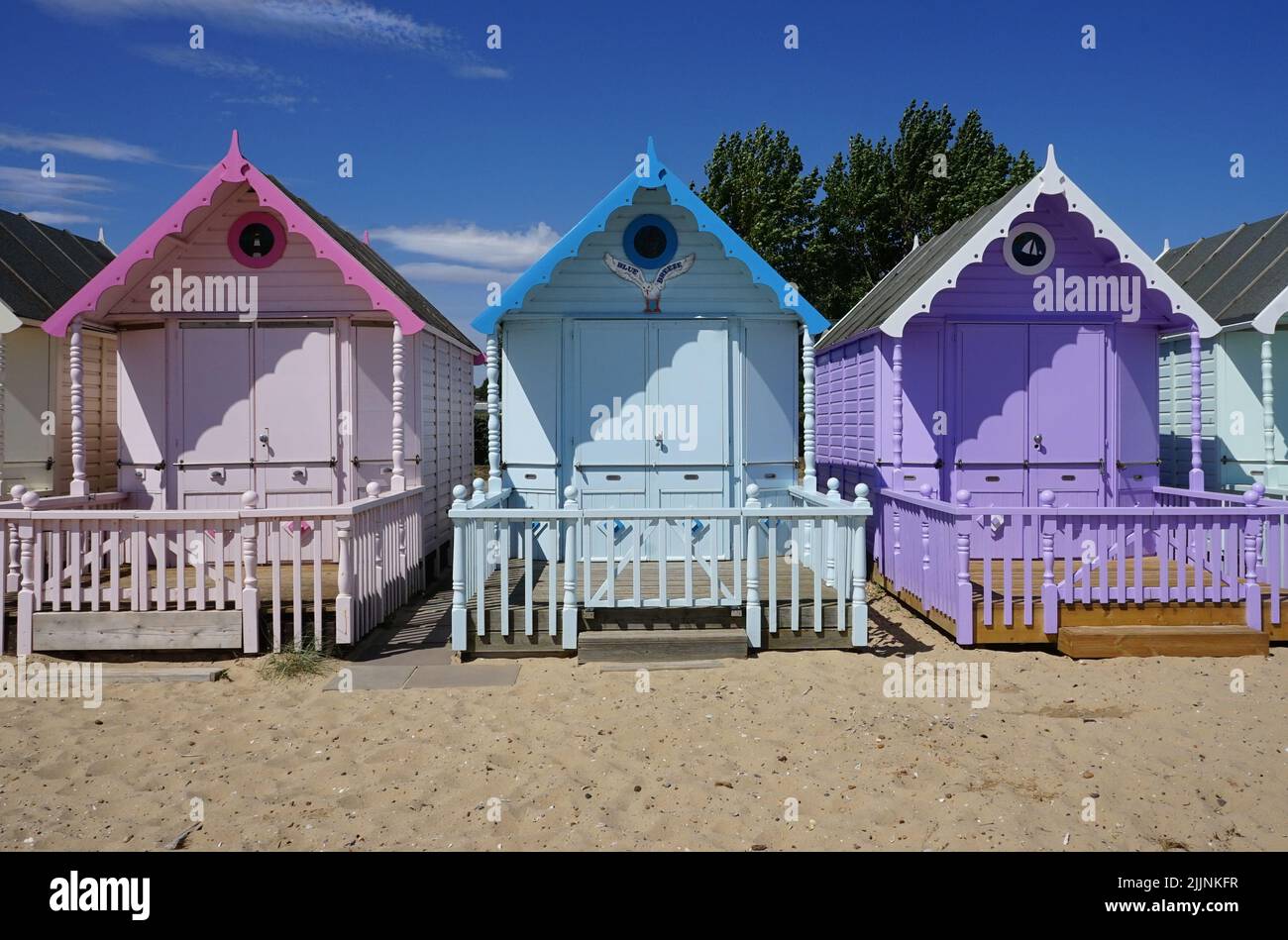 Colourful Wooden English Beach Huts in the sun Stock Photo - Alamy