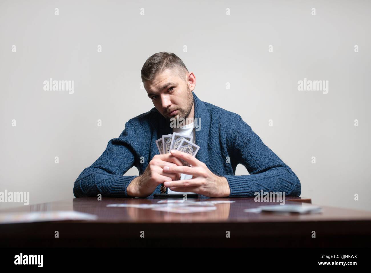 a man is a card player at a table with cards in his hands Stock Photo ...