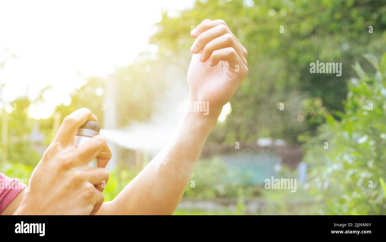 Young man using insect repellent against some kind of insects ...