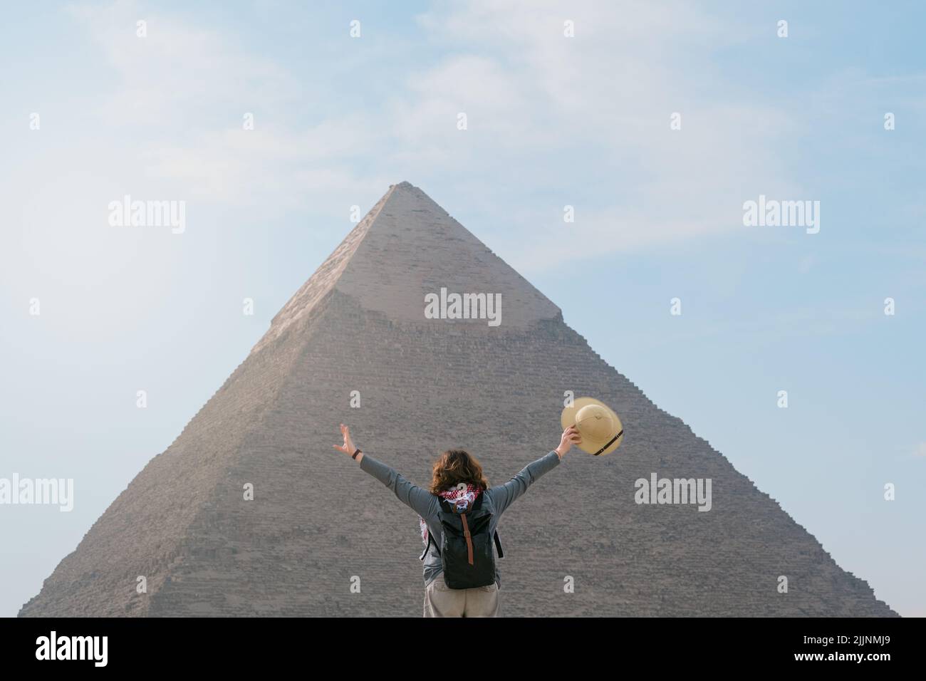 back view of tourist woman standing in front of a pyramid. Egypt, Cairo ...