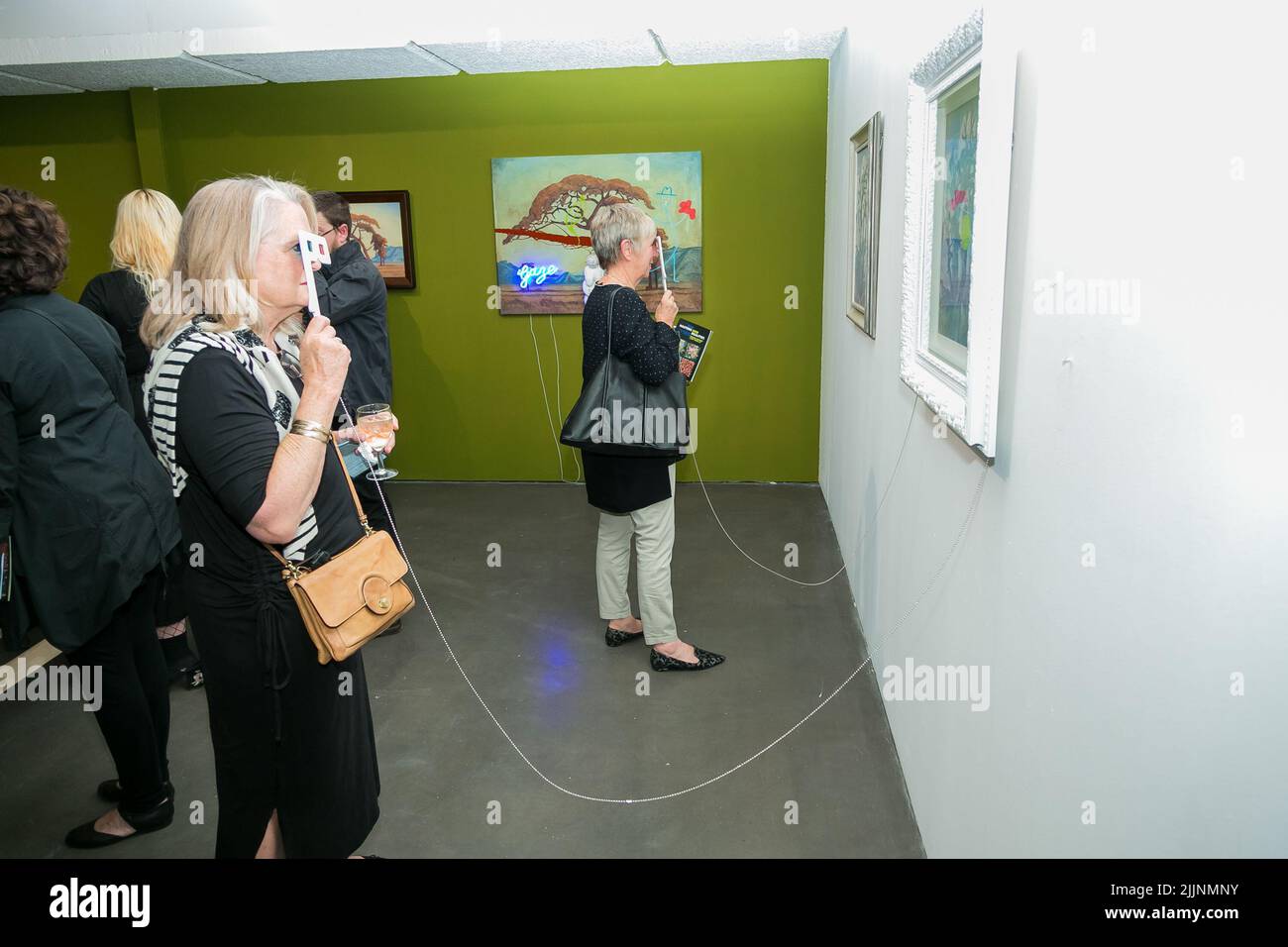The visitors viewing the art exhibit in the gallery Stock Photo - Alamy
