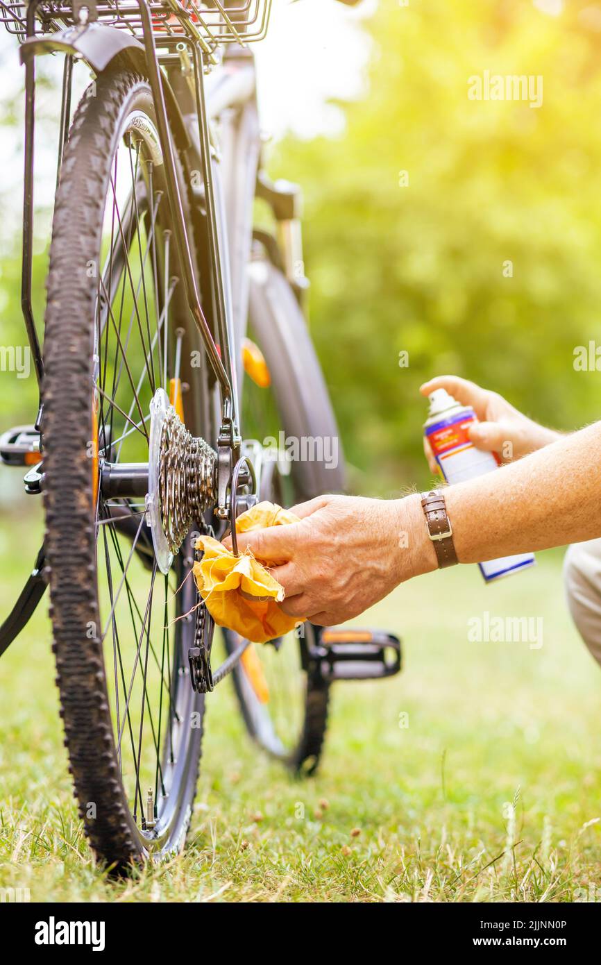 Senior man hand cleaning the bike by spray and rag, doing maintenance ...