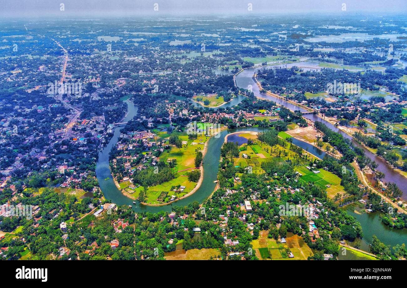 An aerial view of the flowing Karnaphuli River surrounded by greens in ...