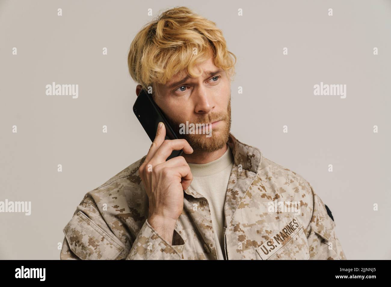 White military man wearing uniform talking on mobile phone isolated ...