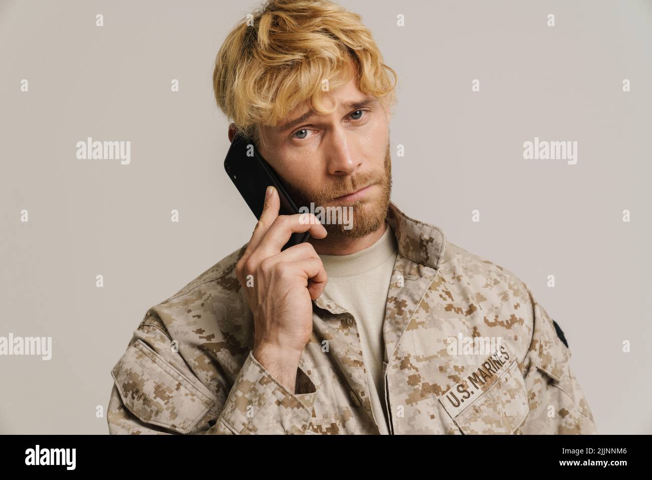 White military man wearing uniform talking on mobile phone isolated ...