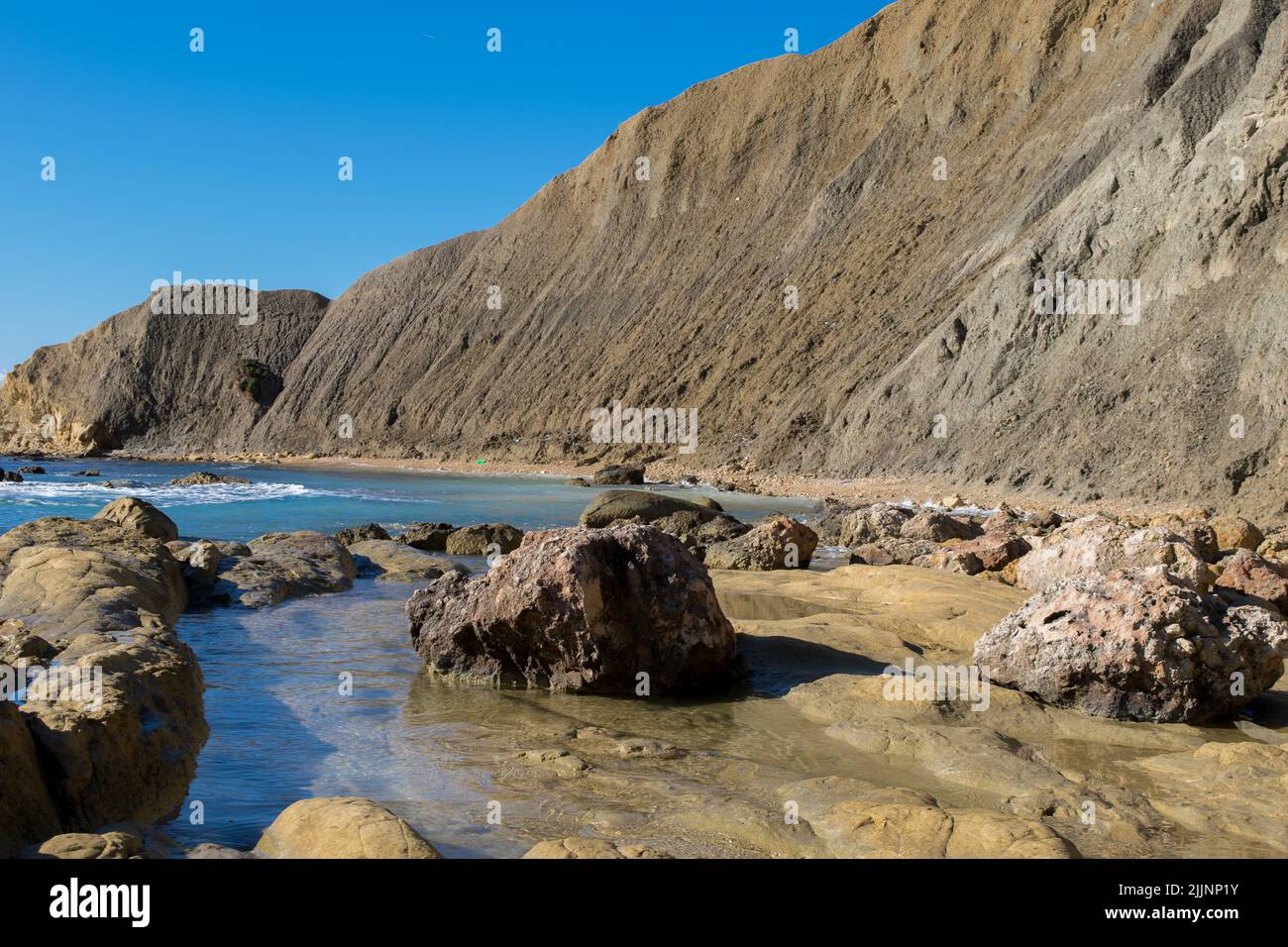 Steep blue clay slopes, with flaking debris forming scree on limestone ...