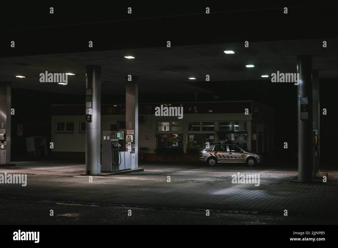A dark night view of a car at a gas station Stock Photo - Alamy