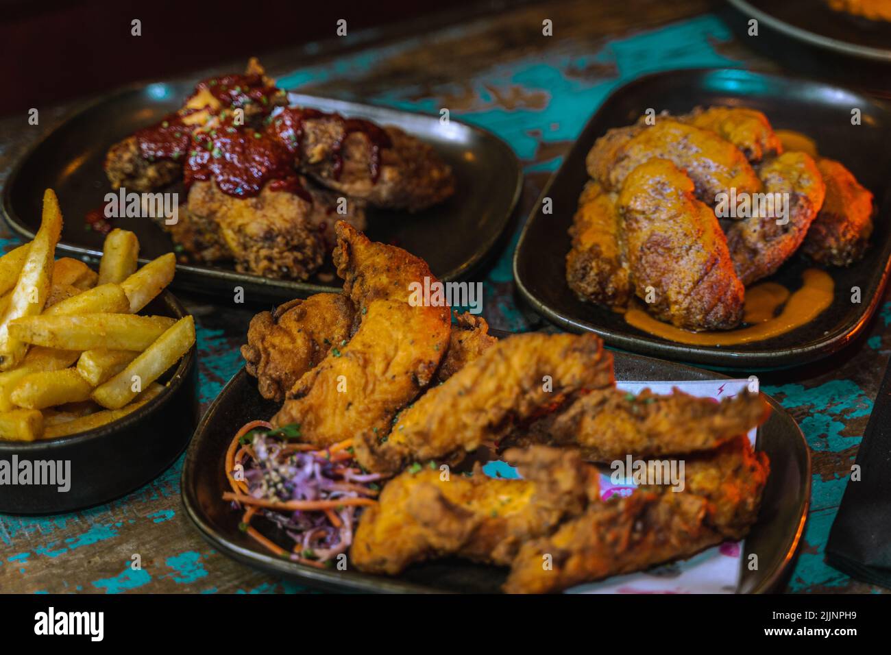 The chicken burger and wings in a dark grungy restaurant setting Stock ...