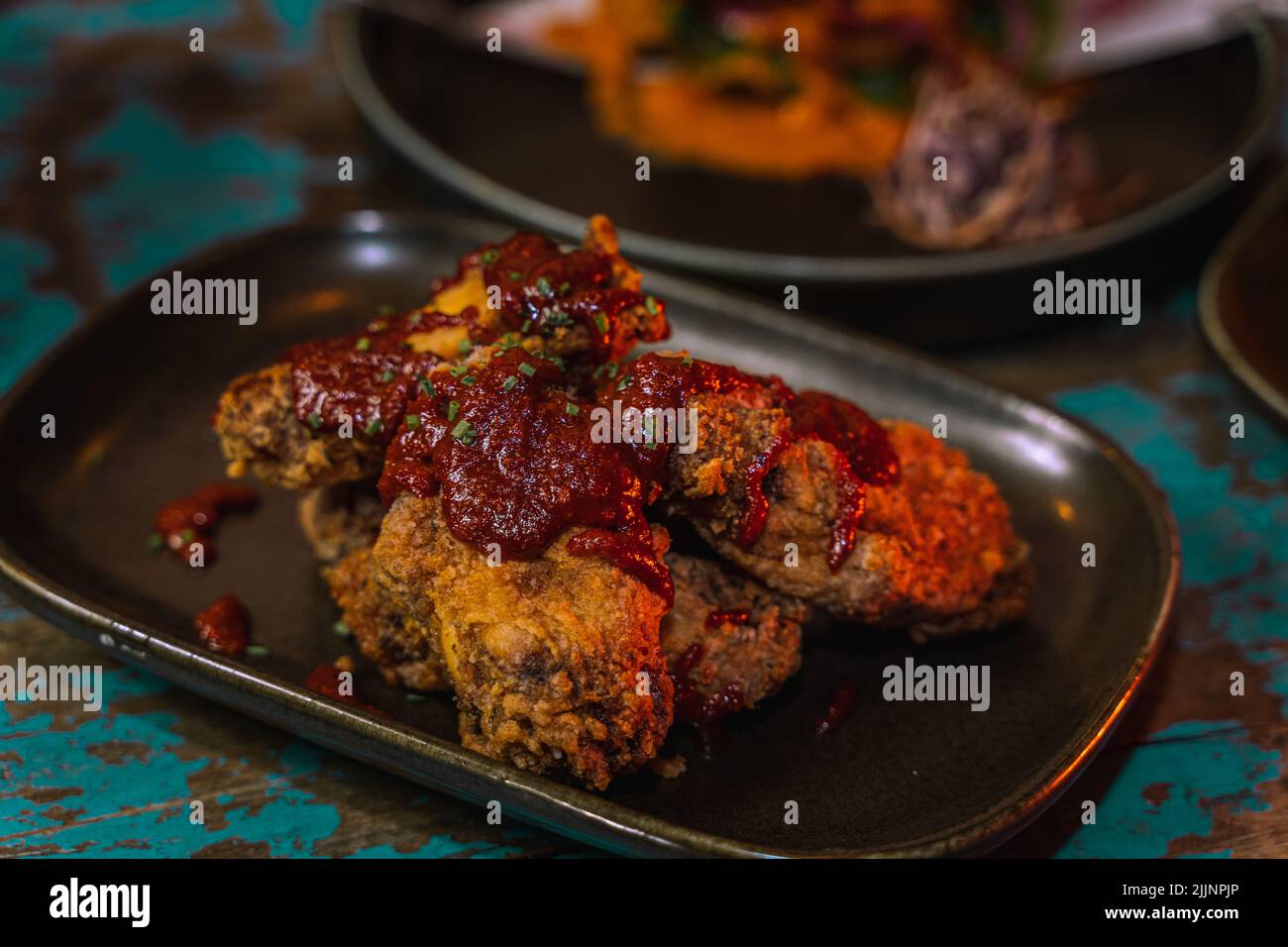 The chicken burger and wings in a dark grungy restaurant setting Stock ...