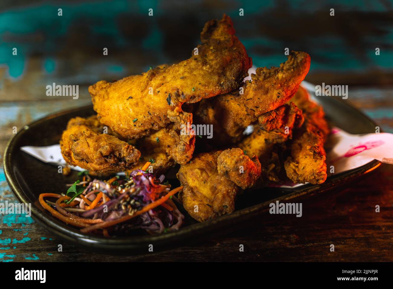 The chicken burger and wings in a dark grungy restaurant setting Stock ...