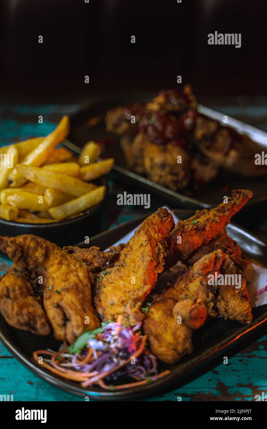 The chicken burger and wings in a dark grungy restaurant setting Stock ...