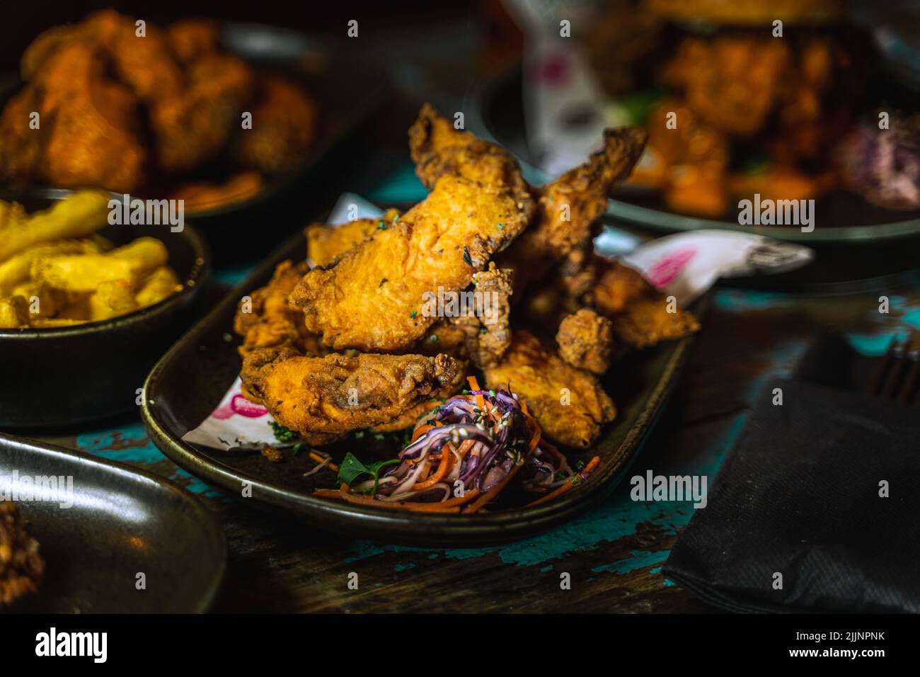 The chicken burger and wings in a dark grungy restaurant setting Stock ...