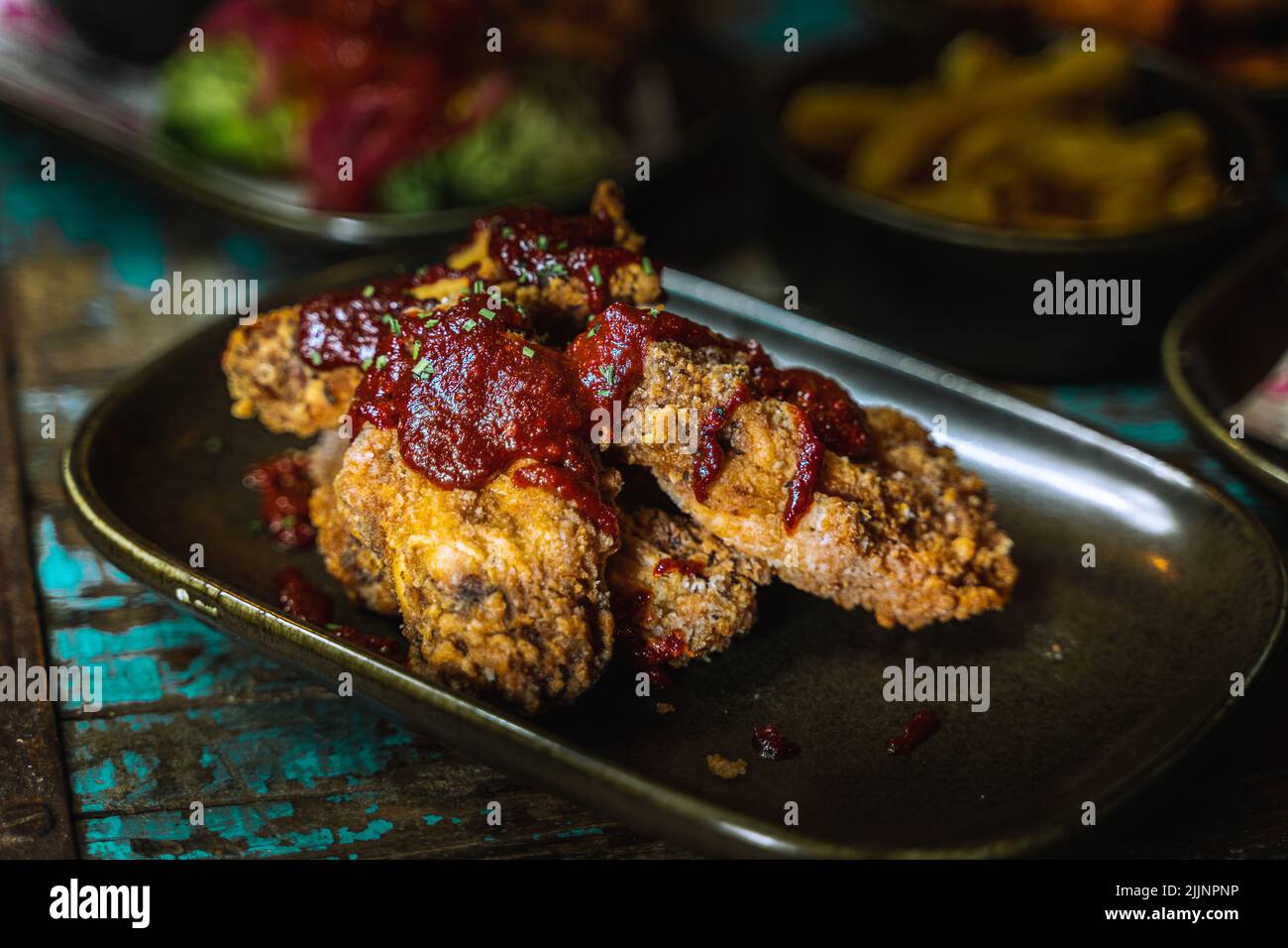 The chicken burger and wings in a dark grungy restaurant setting Stock ...