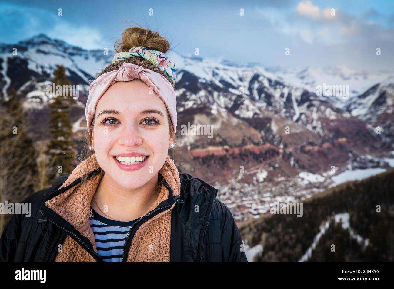 A happy Caucasian woman with blonde hair standing in background of ...