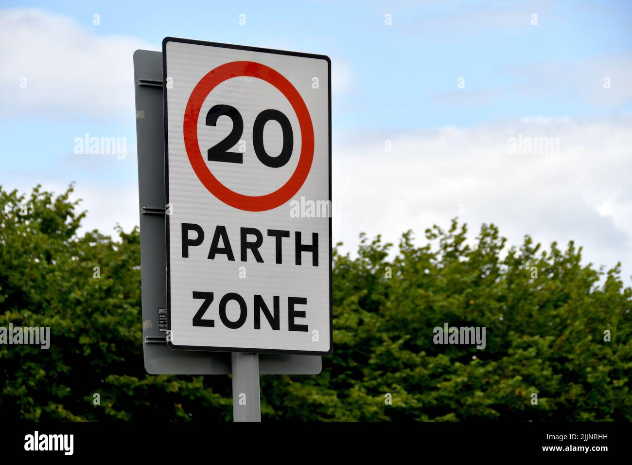 Bilingual road sign showing a 20 mph speed limit at the approach to a ...