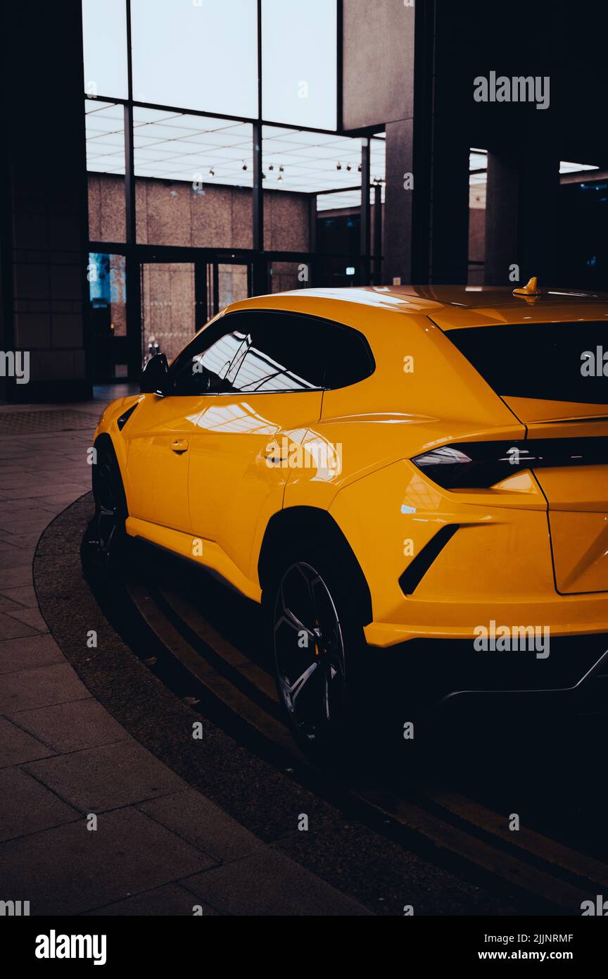 A vertical closeup shot of the yellow Lamborghini Urus from the back ...