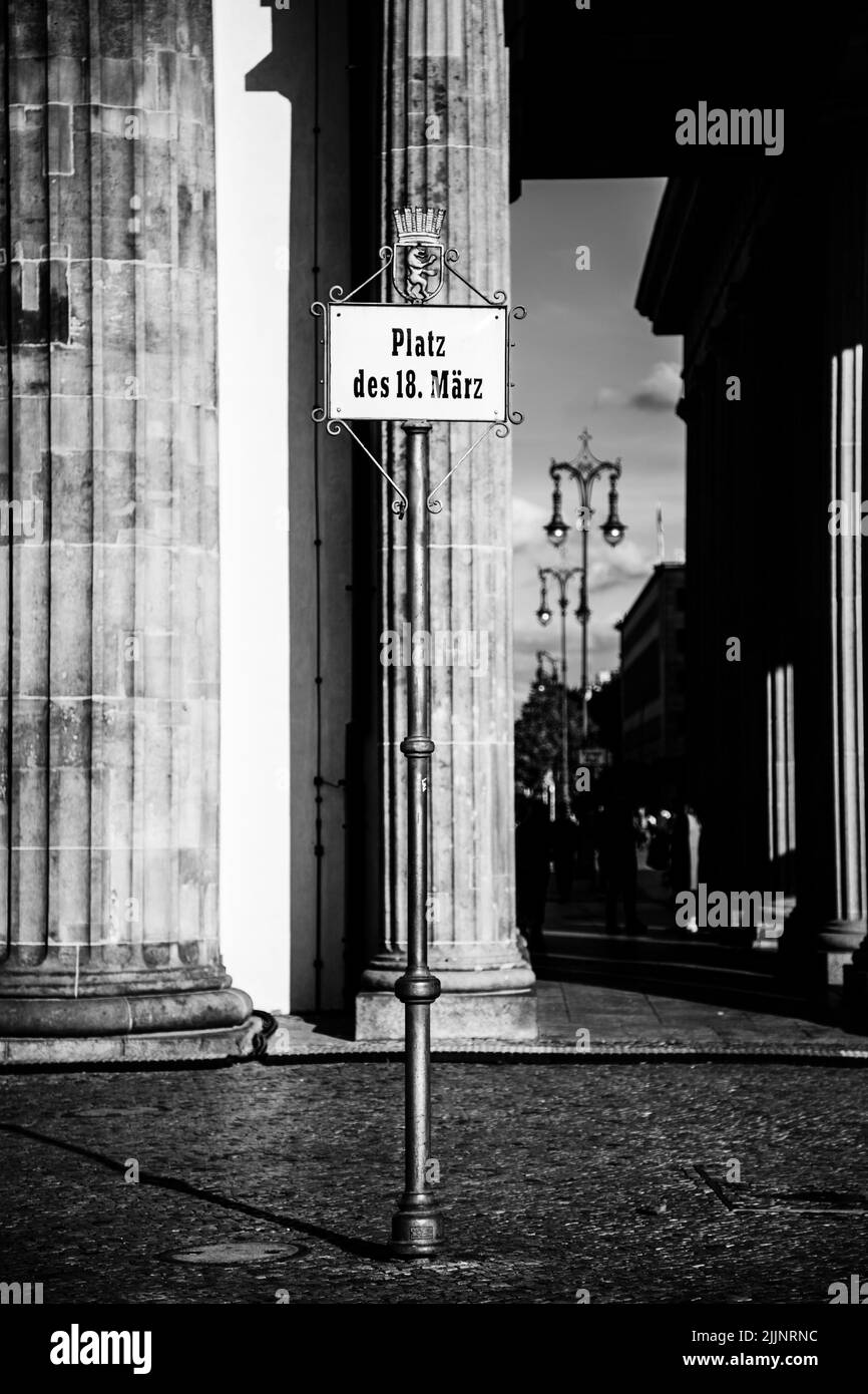 A vertical grayscale shot of a sign in front of the Brandenburg gate in ...