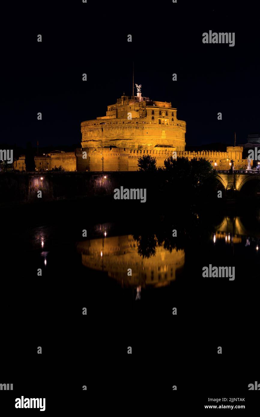 A vertical shot of the Mausoleum of Hadrian at night and its reflection ...
