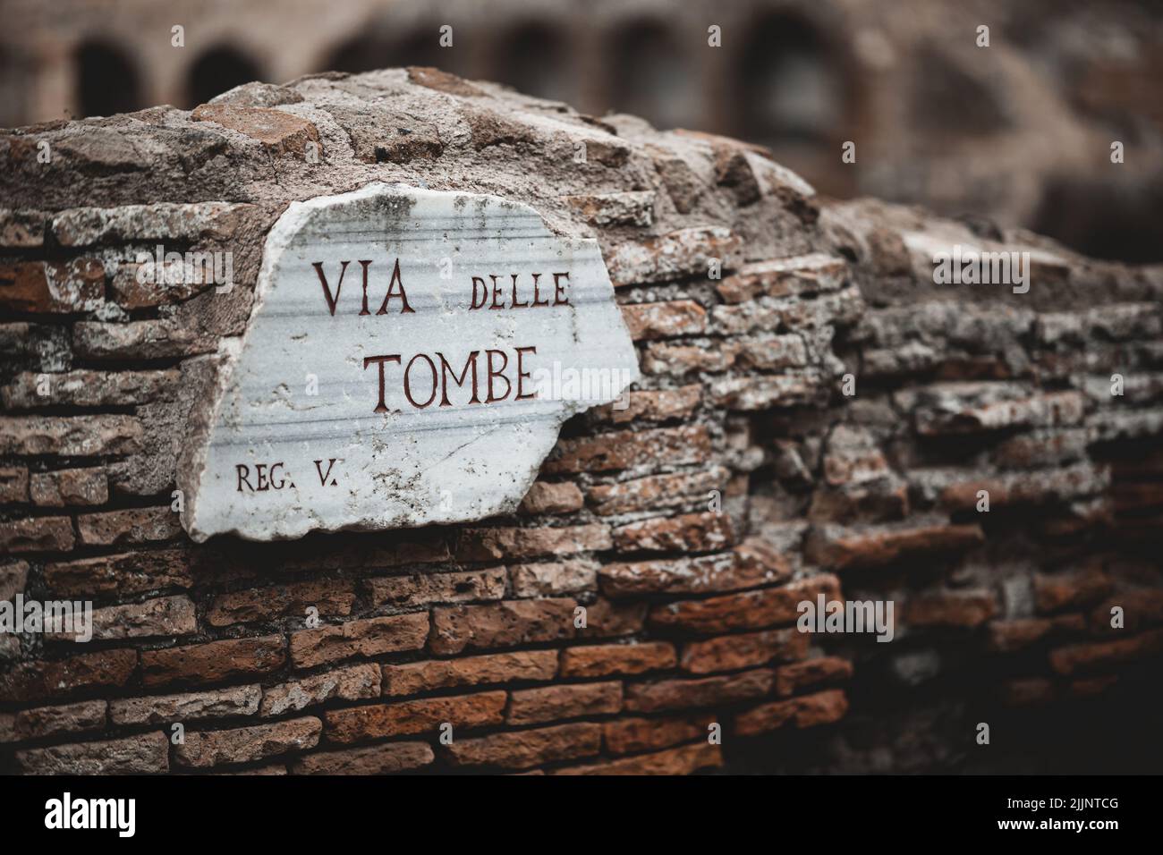 A broken weathered and damaged marble roman inscription placed on a ...