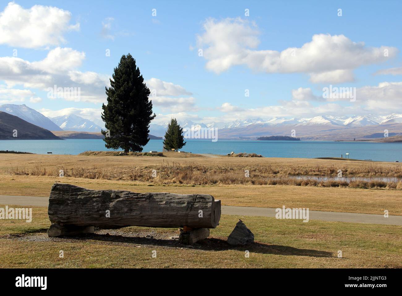 A wooden bench in front of Lake Tekapo in New Zealand during daylight ...