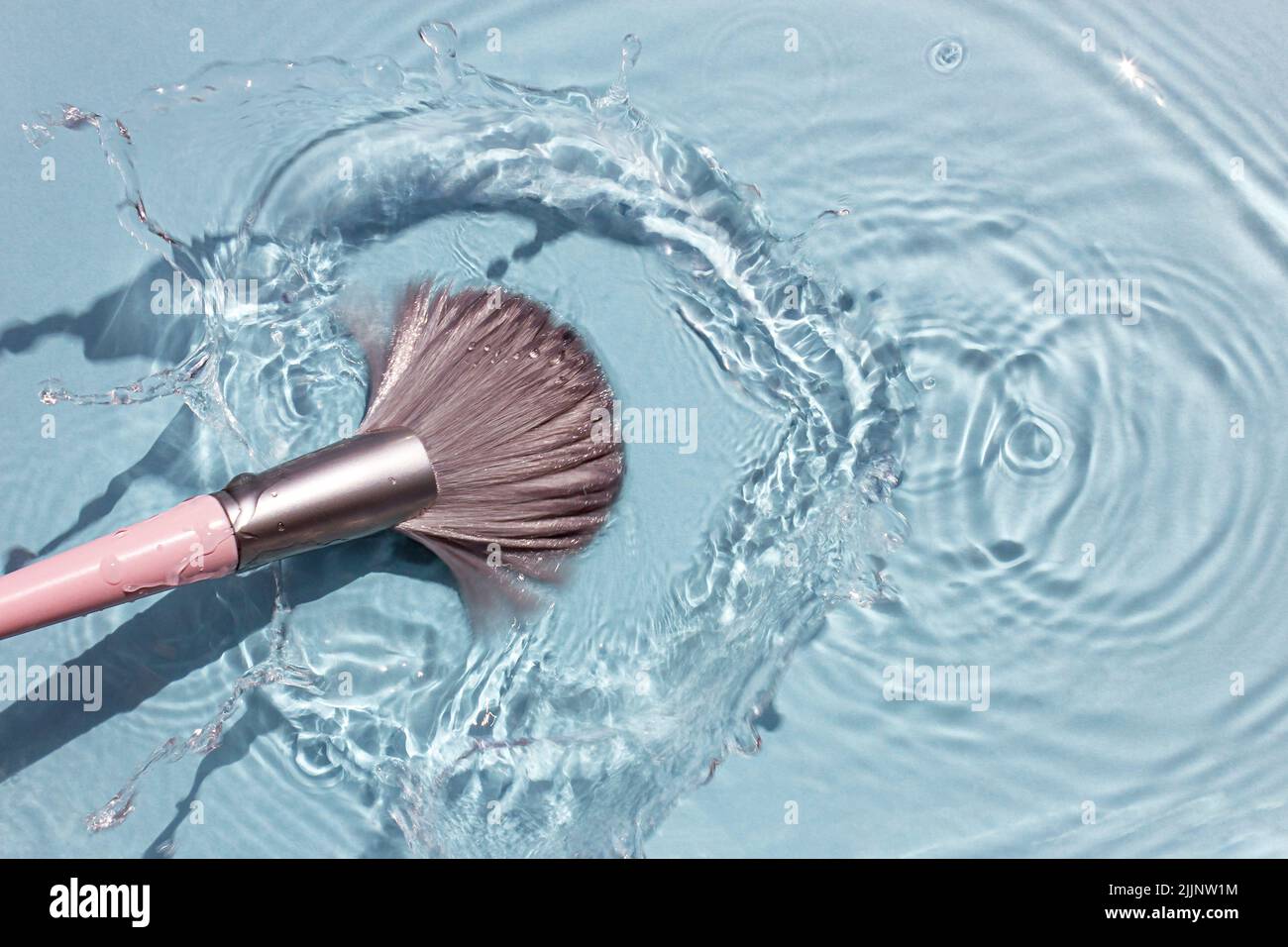 Makeup brush in clean water with a splash. Summer cosmetics concept ...