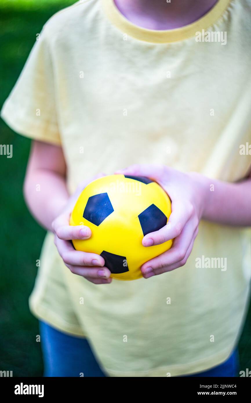 Close-Up of a boy holding a football under his arm Stock Photo - Alamy