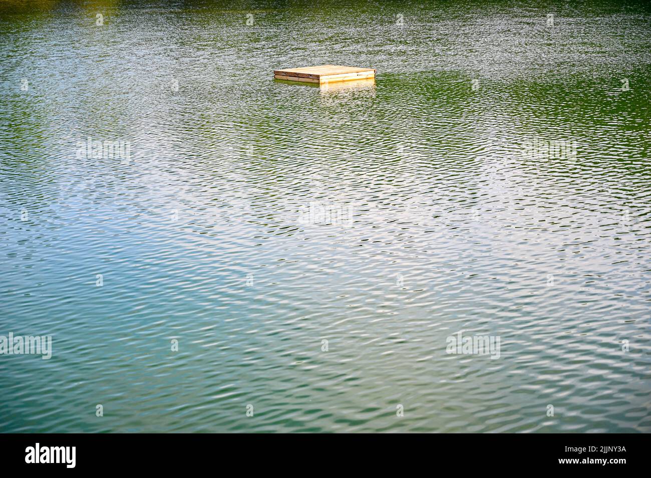 calm water with wooden raft in the middle of the lake in Kumla Sweden ...